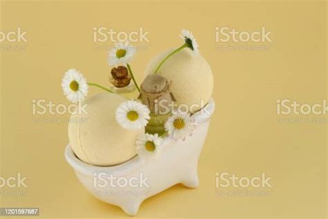 카모마일 추출물을 함유한 목욕 폭탄유기농 천연 바디 화장품 밝은 노란색 배경에 장식 흰색 목욕 목욕 폭탄 공과 데이지 꽃 목욕