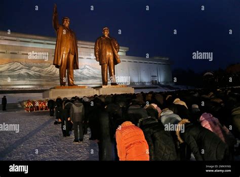 North Koreans Bow At The Bronze Statues Of Their Late Leaders Kim Il