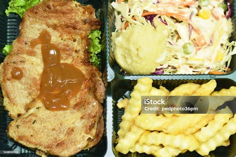 구운 돼지고기 후추 스테이크 드레싱 그레이비 소스와 으깬 감자와 샐러드를 플라스틱 포장에 담그는 칠리 소스를 집으로 가져갑니다 Salty Snack에 대한 스톡 사진 및