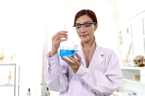 아름다운 아시아 여성 과학자의 초상화는 실험실 코트와 안전 안경을 착용하고 행복한 미소 연구원 여성이 서서 실험실에서 카메라에