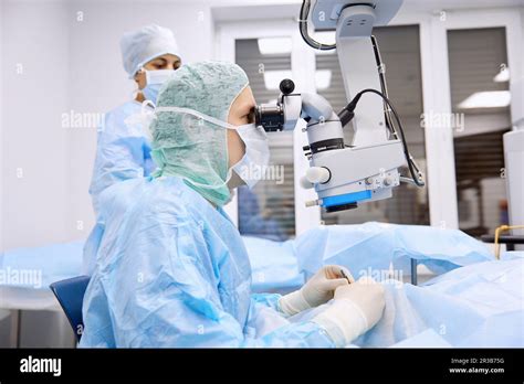 Surgeon Performing Eye Surgery With Microscope In Operating Room Stock