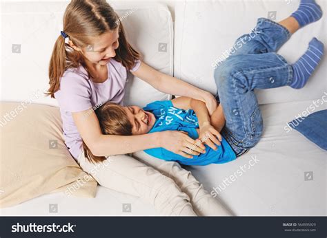 Sister Tickling Her Brother On Sofa Foto De Stock 564935929 Shutterstock