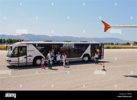 People Leaving An Airport Passenger Transfer Bus About To Board A Plane