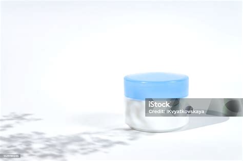 크림 또는 복권과 꽃 그림자가있는 화장품 흰색 항아리 파란색 뚜껑 일광과 거친 그림자가있는 흰색 배경 0명에 대한 스톡 사진 및 기타 이미지 Istock