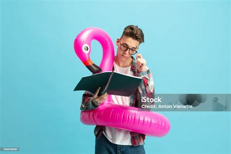 젊은 백인 남자의 절반 길이 초상화 메모장과 밝은 파란색 배경에 고립 된 수영 원을 가진 학생 남자에 대한 스톡 사진 및 기타 이미지 Istock