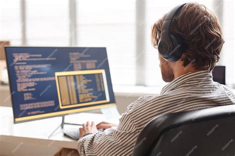 Premium Photo Male It Developer Using Computer At Desk In Office And Wearing Headphones
