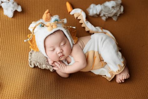 드래곤 의상을 입고 평화롭게 잠자는 사랑스러운 아기 · 무료 스톡 사진