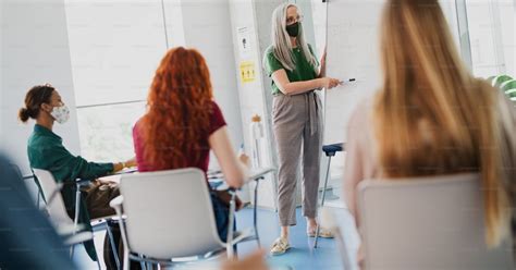 실내 교실에 교사가 있는 대학생의 뒷모습 코로나바이러스 및 정상 개념으로 돌아갑니다 사진 Unsplash의 슬로바키아 이미지