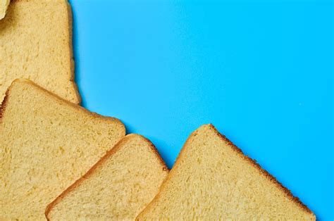 토스트를 위한 노란 바닐라 빵의 흩어진 사각형 조각은 부엌의 파란색 테이블에 놓여 있습니다 텍스트의 공백입니다 맨 위 보기 건강한 식생활에 대한 스톡 사진 및 기타 이미지