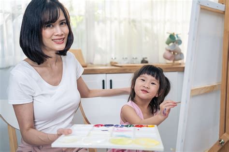 어머니와 함께 그림 보드에 착색 아시아 아이 딸의 초상화 행복한 가족 활동 어린 소녀 아이는 수채화 페인트와 브러시와 함께 예술 사진을 그리는 방법을 배우고 엄마와 창의력을