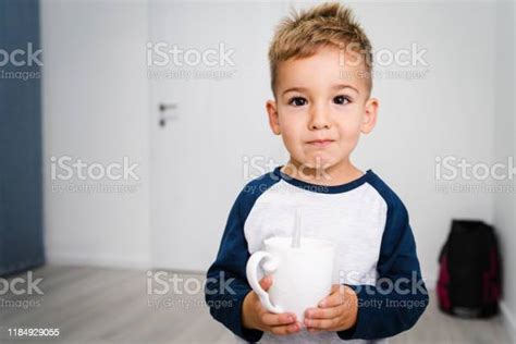 집에서 손에 들고 차 또는 우유의 흰색 컵으로 서 있는 작은 소년 2 3 살에 대한 스톡 사진 및 기타 이미지 2 3 살
