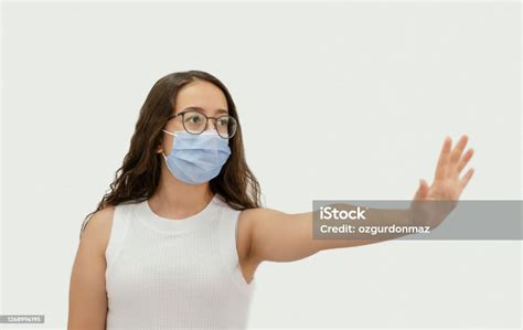 바이러스 전염병 동안 그녀의 얼굴에 보호 마스크를 착용하는 동안 십대 소녀는 정지 표지판을 제스처 18 19세에 대한 스톡 사진 및 기타 이미지 Istock