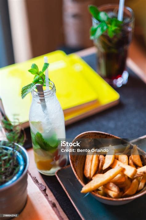 민트와 라임을 곁들인 상쾌한 레모네이드 책과 식물이 놓인 카페 테이블 위에 소박한 그릇에 담긴 바삭한 감자튀김 옆 0명에 대한 스톡 사진 및 기타 이미지 Istock