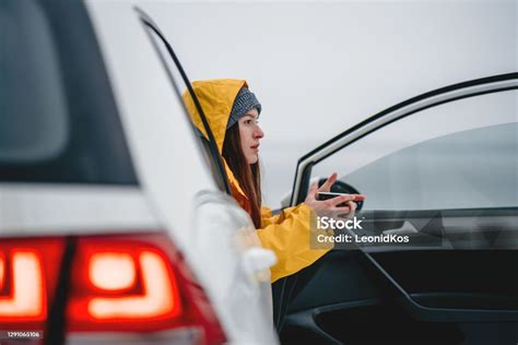 혼자 여행자 여성은 그녀의 여행 동안 자동차와 겨울 풍경을 멀리 보고 휴식 차에 앉아 펜시브 여성과 차 한 잔과 함께 따뜻하게