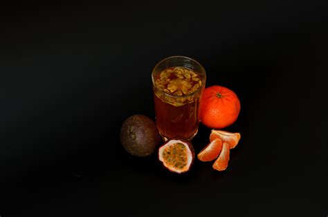 잘 익은 귤과 패션프루트 조각 옆에 검은색 배경에 씨앗이 있는 과일 주스 한 잔 감귤에 대한 스톡 사진 및 기타 이미지 감귤