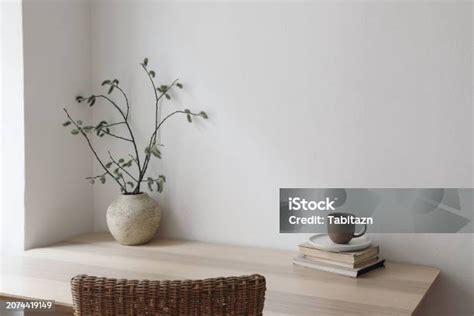 스칸디나비아 거실 인테리어 커피 한 잔 나무 테이블에 책 버드 나무 가지 꽃병에 캣킨 등나무 의자 우아한 스칸디 업무 공간 홈 오피스 빈 베이지색 벽 배경 0명에 대한 스톡