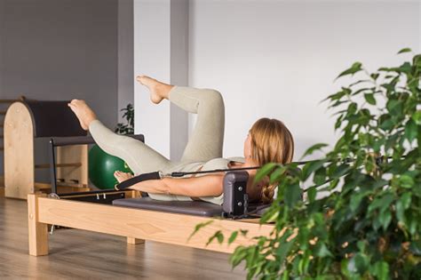 개혁자 침대에서 필라테스를 훈련하는 여성 체육관에서 피트니스 운동을 위한 리포머 필라테스 스튜디오 머신 적합 하 고 건강 하 고 강한 진정한 몸매 피트니스 개념 여자에 대한