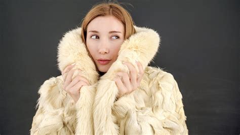 크림색 모피 코트를 입은 갈색 머리의 젊은 여성의 얼굴 사진으로 검은색 배경의 스튜디오 환경에서 촬영되었습니다 20 24세에 대한 스톡 사진 및 기타 이미지 Istock