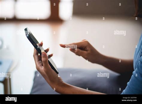 Asian Woman Controlling Smart Home Mobile Phone With Smart Home App In