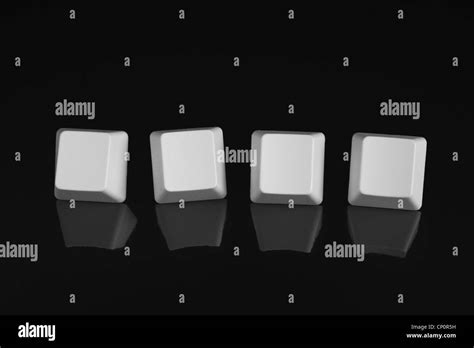 A Set Of Four Blank Computer Keyboard Keys On A Black Surface Stock