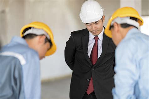 검은 양복과 붉은 넥타이 흰색 헬멧에 사업가 앞 모습 이다 흐림 전경 엔지니어와 노란색 헬멧에 건축가 개념에 대한 스톡 사진 및 기타 이미지 Istock