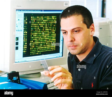 An Adult Caucasian Male Laboratory Technician Sitting At Computer That Displays A Microarray