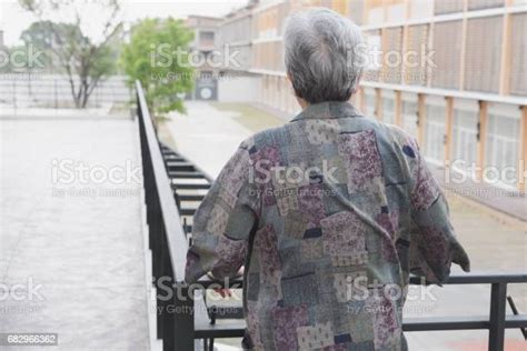 발코니에 서 있는 노인 테라스에서 좋은 날씨를 즐기는 노인 아시아 여성 날씨에 대한 스톡 사진 및 기타 이미지 날씨 도시 도시 경관 Istock