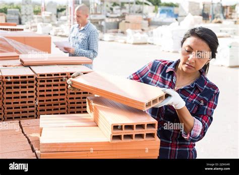 Female Worker Stacking Bricks In Warehouse Of Materials Stock Photo Alamy