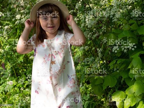 예쁜 어린 소녀가 꽃을 따고 있습니다 밀짚 모자를 쓴 햇볕이 잘 드는 아이가 초록색 숲에서 민들레를 따고 있다 여름 소녀입니다 귀여운에 대한 스톡 사진 및 기타 이미지