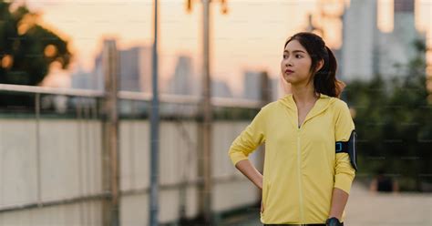 아름 다운 젊은 아시아 운동 선수 아가씨는 도시 환경에서 스트레칭 운동을합니다 이른 아침에 보도 다리에서 운동복을 입은 일본 십대 소녀 도시에서 활약 하는 라이프 스타일