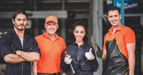 제복을 입은 전문 엔지니어 동료인 팀워크 컨셉의 엄지손가락을 치켜들고 차고 앞에서 밀링하는 정비사 팀의 초상화 단체 사진 사진