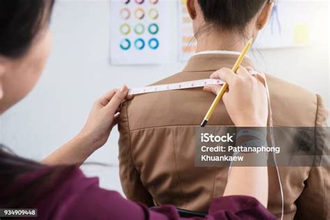 젊은 여 자가 양 장점 또는 고객 직업 및 직업 직업 디자이너 세련 된 컨셉으로 옷에 대 한 측정으로 작동 하는 디자이너