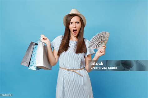 여름 복장 쇼핑 후 구매와 패키지 가방을 들고 밀 짚 모자에에서 초상화 화가 여자 많은 달러 지폐 현금 돈 파란색 배경에 고립 광고에 대 한 공간을 복사 합니다 가방에 대한