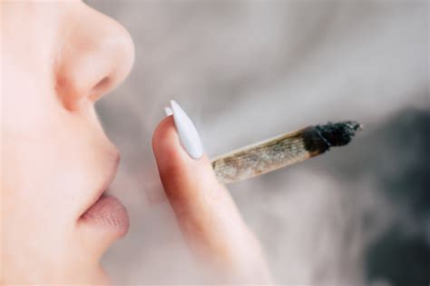 마리화나 대마초 A 여자 담배 합동 및 그의 손에 라이터 연기가 검은 배경에 의료 마리화나 사용과는 대마초의 합법화의 개념 건강관리와 의술에 대한 스톡 사진 및 기타 이미지