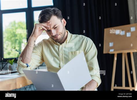 Focused Businessman Looking At Blurred Paper Folder In Office Stock Image Stock Photo Alamy