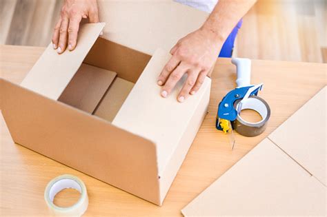 포장 기계를 들고 골판지 또는 종이 상자를 밀봉하는 작업자 손 가정의 방에 대한 스톡 사진 및 기타 이미지 가정의 방 남자 배경 주제 Istock