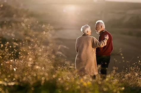 在秋天的日子里，快乐的老夫妇聊天的背影。照片下载