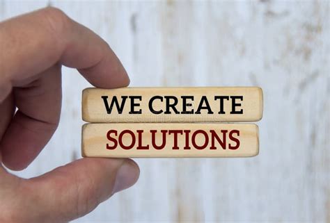 hand holding wooden blocks with text we create solutions problem