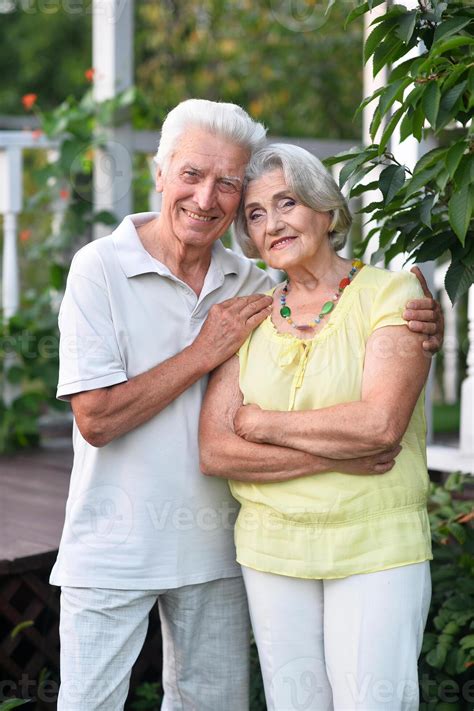 Portrait Of Beautiful Senior Couple By Lilacs In The Park 53568296