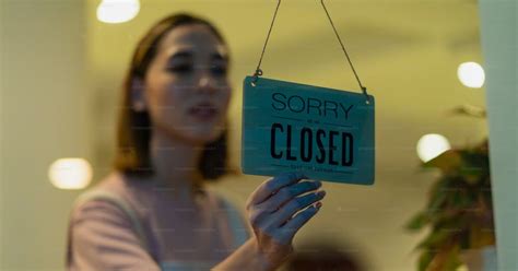 아시아 여성 커피 숍 바리 스타가 카페 문으로 걸어 가서 매달린 닫힌 표지판을 돌립니다 고객에게 서비스를 제공하기 위해 레스토랑을 준비하는 여성 웨이트리스 중소 기업