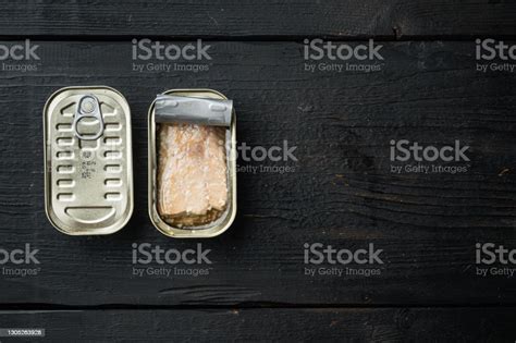 통조림 야생 송어 주석 캔에 검은 나무 테이블 배경에 상단 보기 평면 누워 카피 스페이스와 텍스트 공간을 가진 0명에 대한 스톡