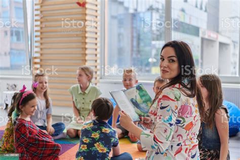 초등학교 또는 유치원에서의 독서 시간 초등학교 또는 유치원의 어린이들에게 책을 읽어주는 교사 유치원 교육의 개념 선택적 초점 특수 교육에 대한 스톡 사진 및 기타 이미지