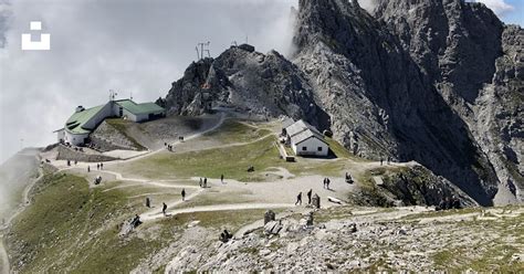 낮에는 흰 구름 아래 록키 산 근처의 푸른 잔디밭에 있는 녹색과 흰색 집 사진 Unsplash의 무료 건물 이미지
