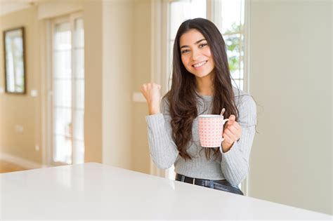 한 잔의 커피를 마시는 젊은 여 자가 자랑 하 고 승리와 성공을 축 하 하는 것은 매우 흥분 응원 감정 가정 생활에 대한 스톡 사진 및 기타 이미지 Istock