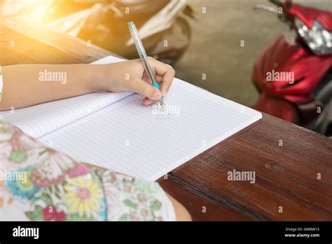 Girl S Hand Holding Pen Writing On Notebook Stock Photo Alamy
