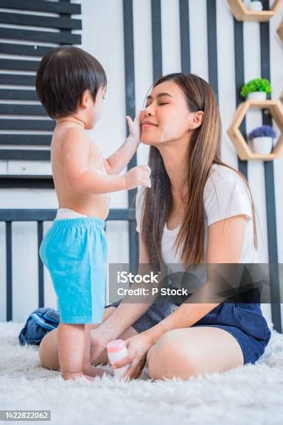 침대에서 귀여운 작은 아들과 놀고있는 어머니는 아들이 가루로 놀고 있습니다 유아에 대한 스톡 사진 및 기타 이미지 유아