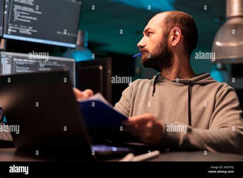 Web Developer Analyzing Source Code With Papers And Computer Taking