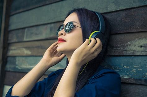 Wanita Muda Asia Yang Bahagia Menggunakan Headphone Untuk Mendengarkan ...