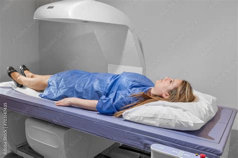 Female Patient Undergoing X Ray Scan Research For Osteoporosis Bone Densitometry Examining