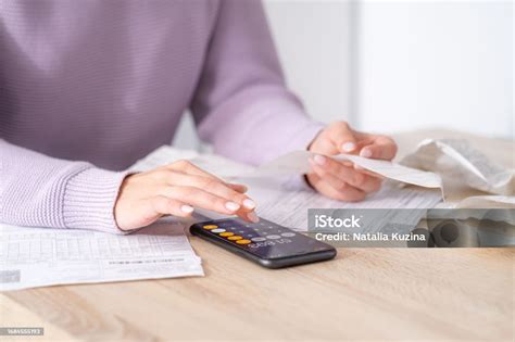 경제적인 여자는 집에서 전화 계산기로 일한다 가제트에 대한 청구서 세금 납부 온라인 선구적인 여성 재정 지출 계산 전화로 가족 가계 예산 계획 관리 러시아에 대한 스톡 사진